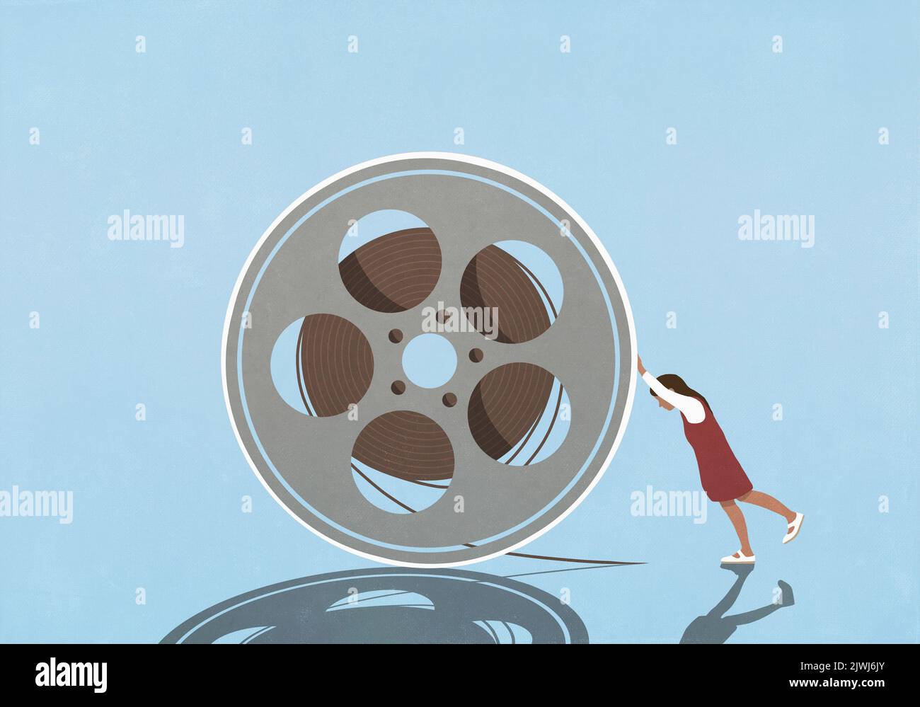 Woman pushing large film reel on blue background Stock Photo - Alamy