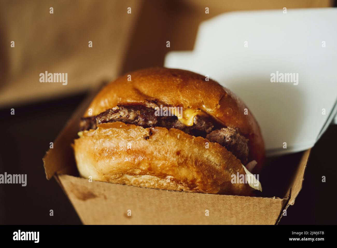 Close up takeout hamburger on brioche bun in container Stock Photo - Alamy