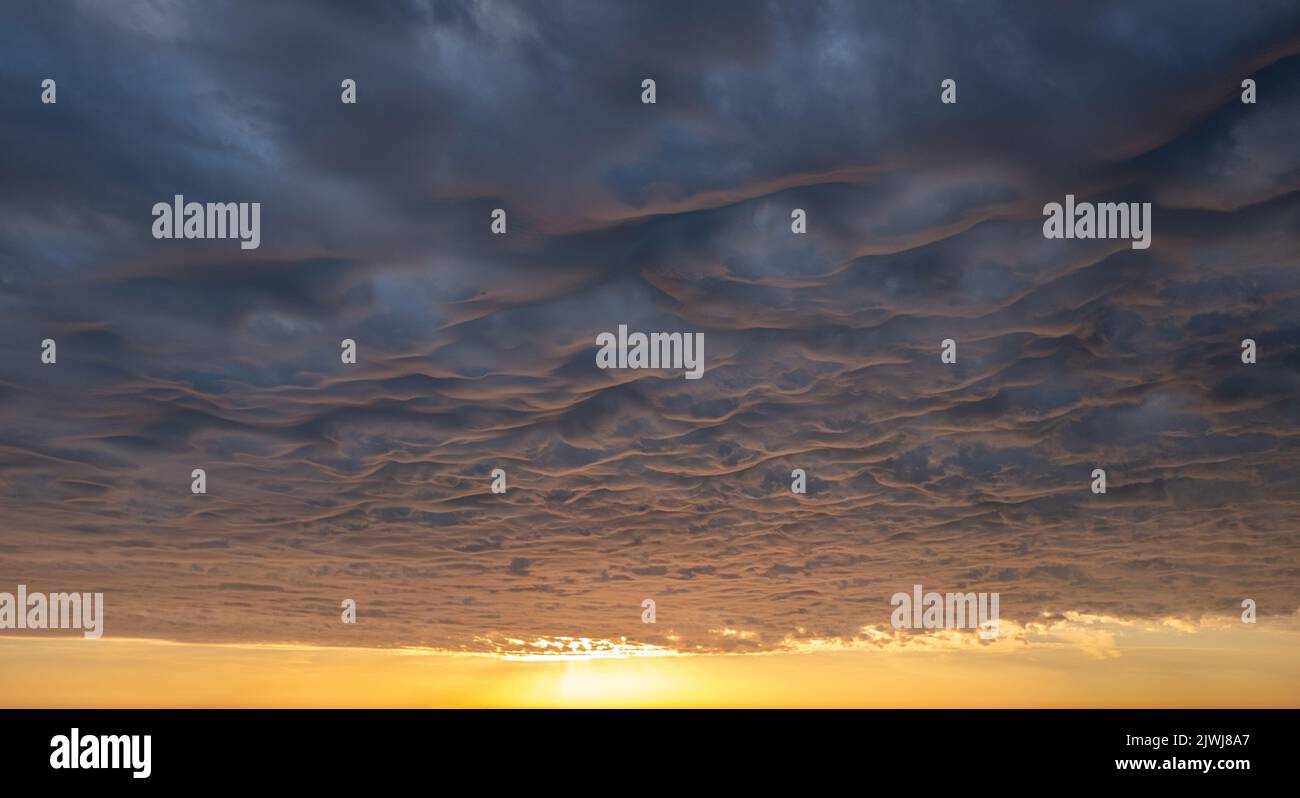 Amazing clouds in the sky and rays of the setting sun Stock Photo - Alamy