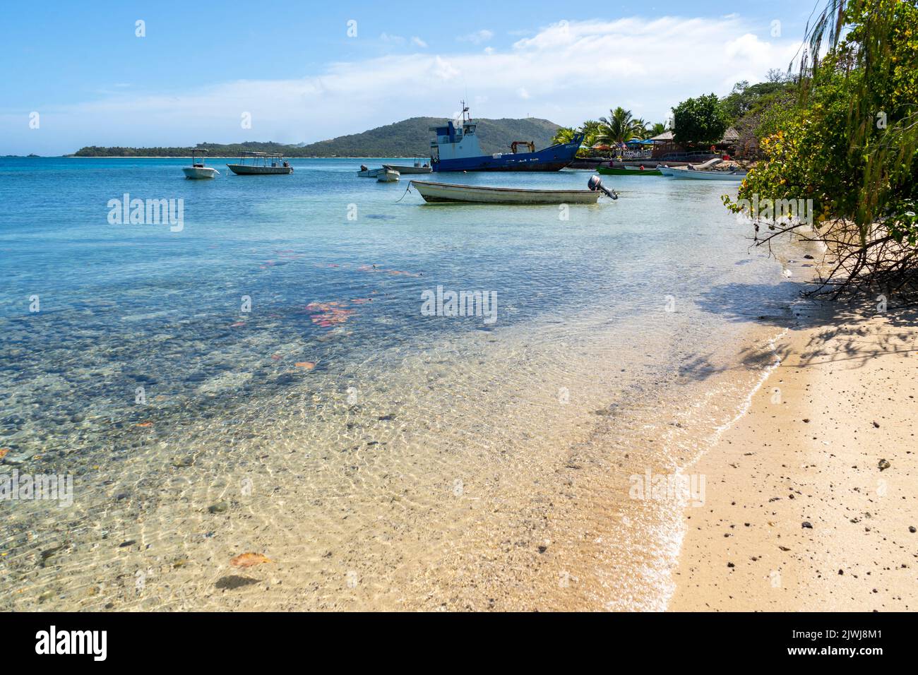 Small boats used by locals for inter-island transport anchored of beach ...
