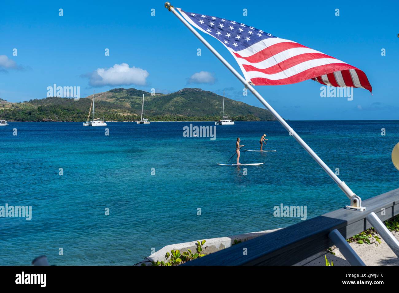 Couple on stand-up paddleboard off Nanuya Island Resort, Yasawa Islands ...
