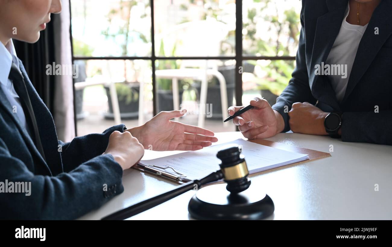 Female lawyer explaining terms, condition on legal document to client ...