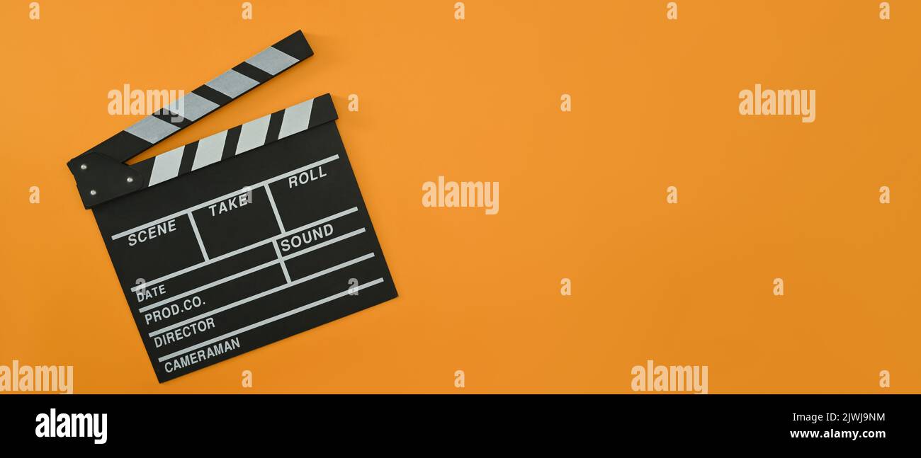 A clapper board on orange background with copy space. Cinema minimal ...