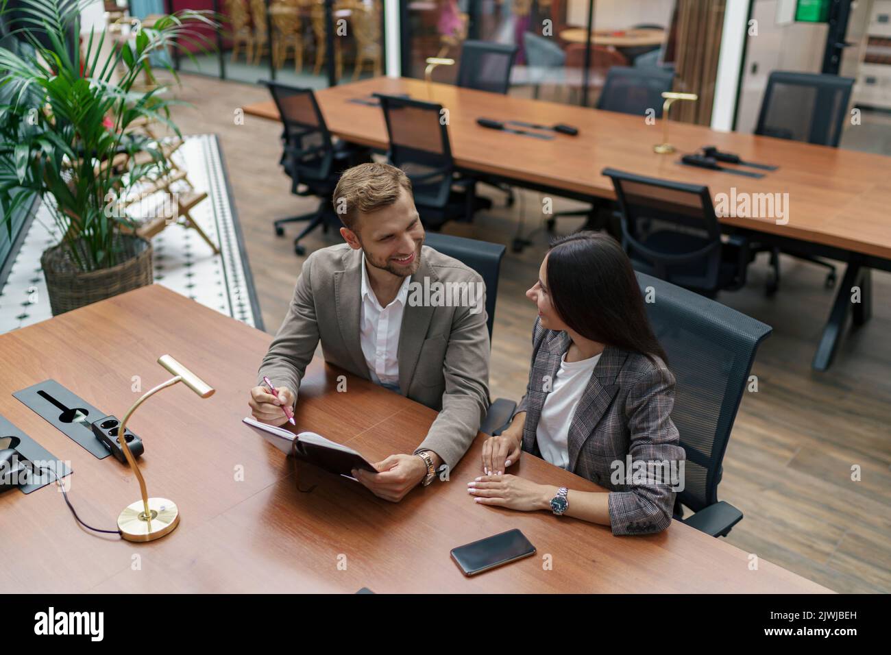 Two businesspartners working laptop together in modern coworking ...