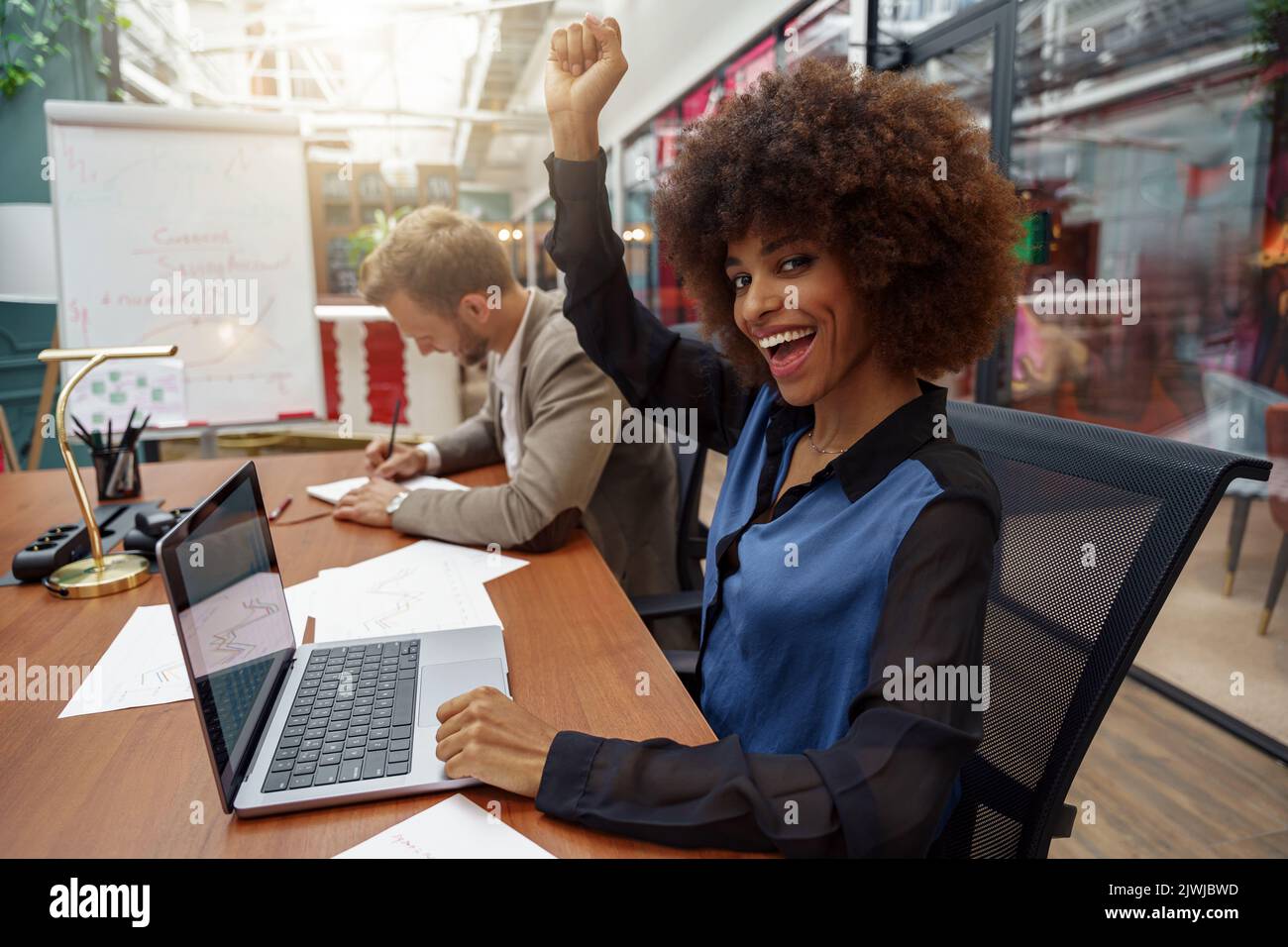 Happy african businesswoman sitting on his workplace in modern office ...