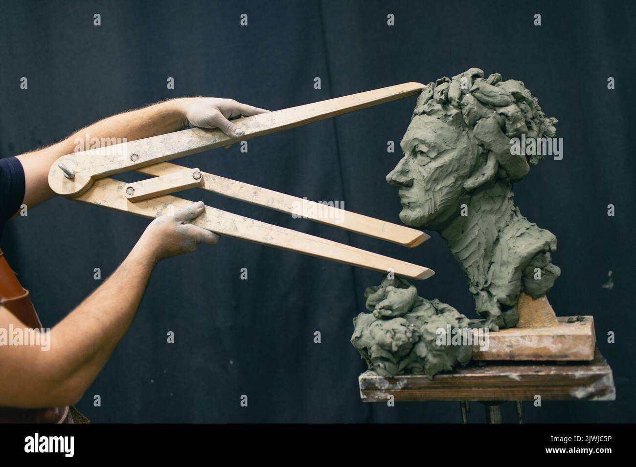 Man sculptor creates sculpt bust clay human measures compass woman head ...