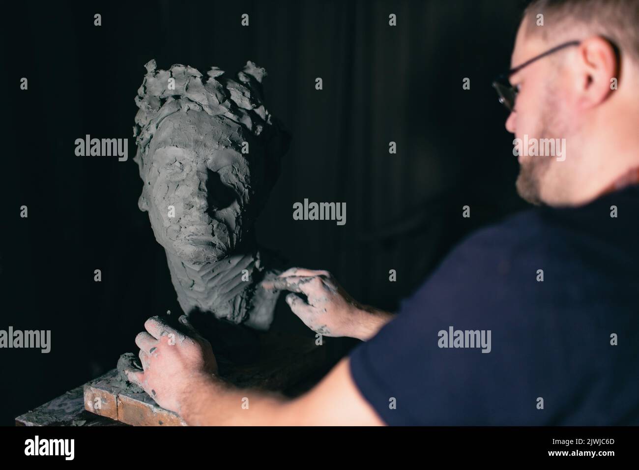 Man sculptor creates sculpt bust clay human woman sculpture. Statue ...