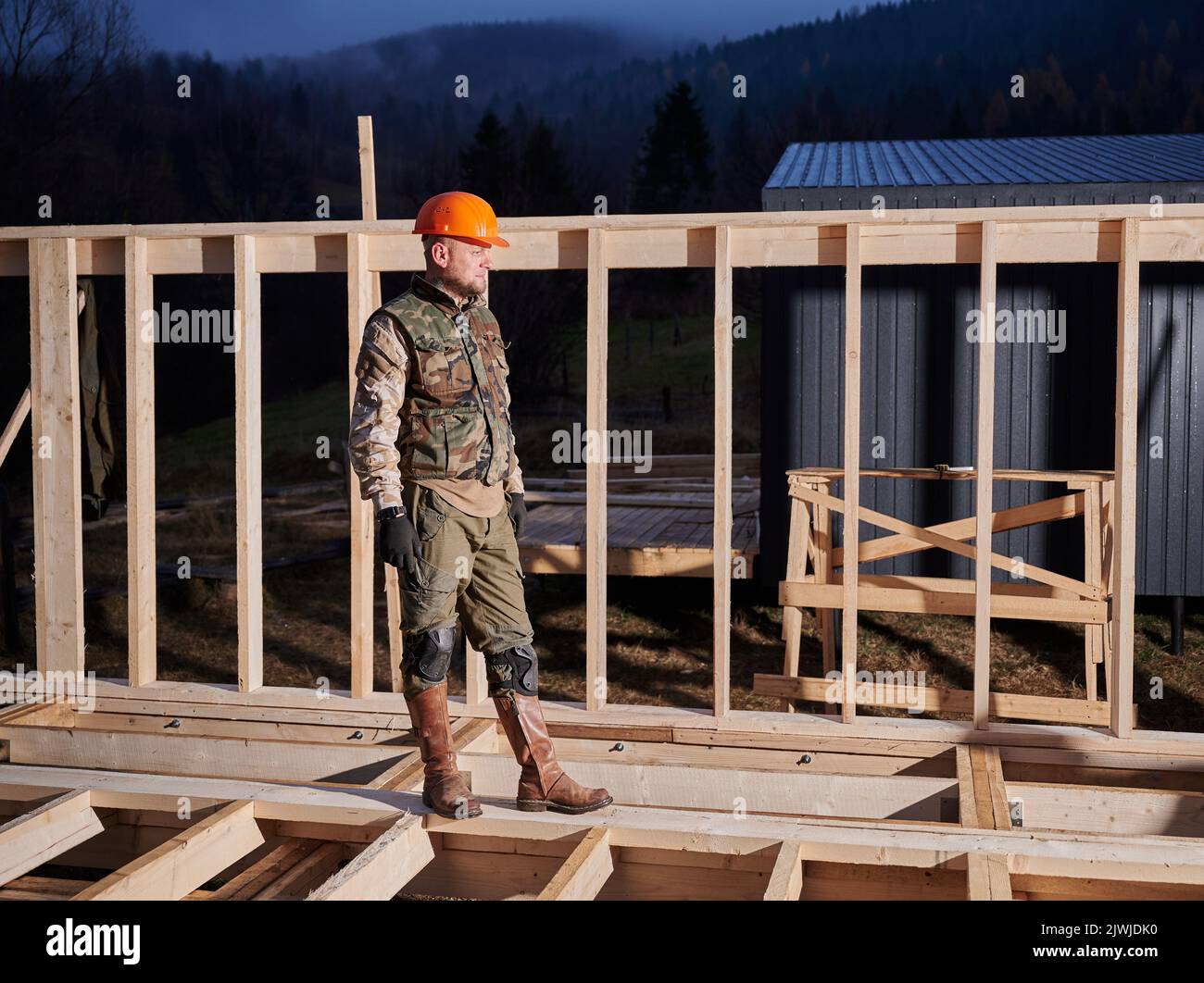 Male developer building wooden frame house. Portrait of man standing on ...