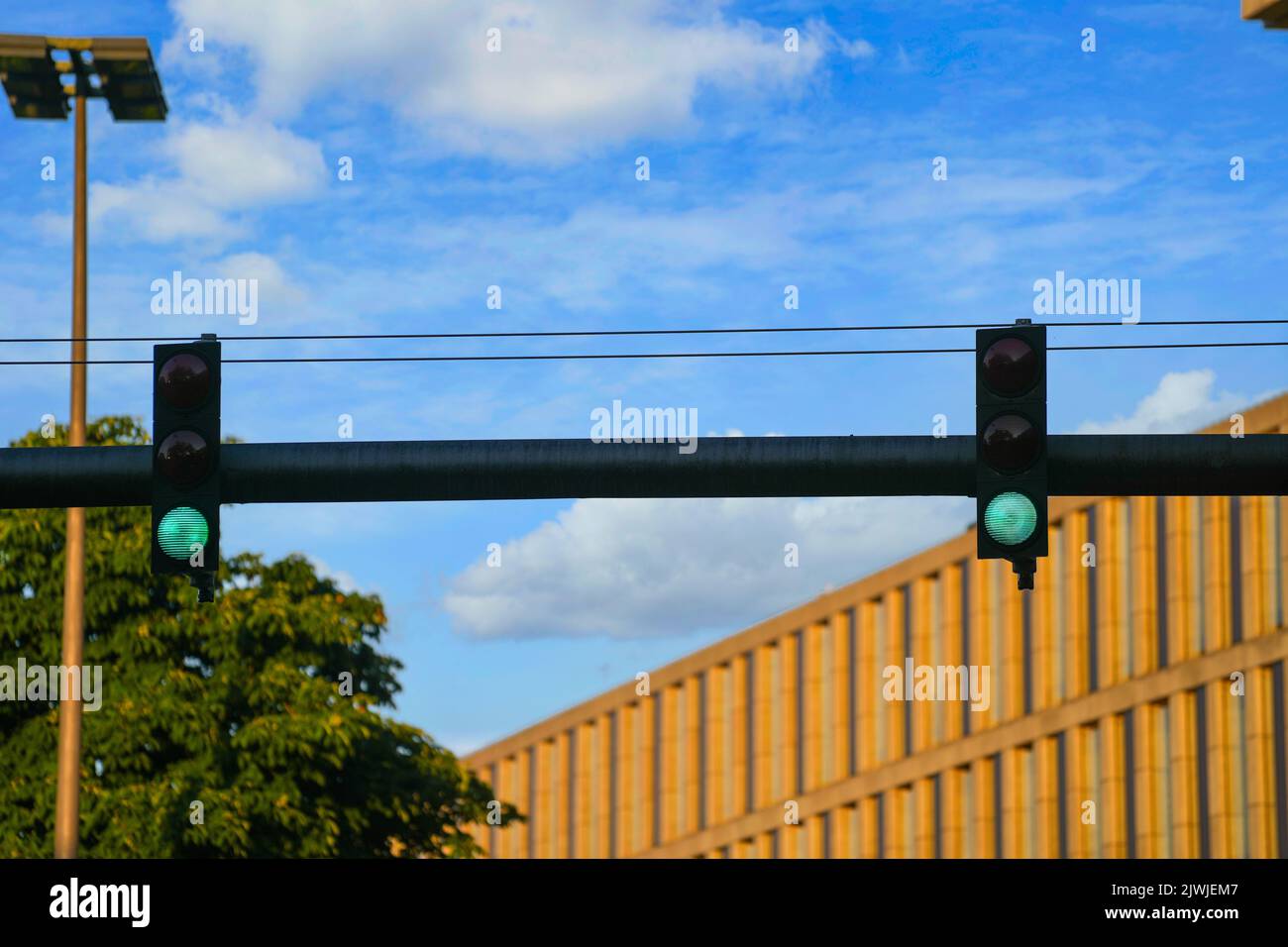 The traffic lights with green light on horizontal pole Stock Photo - Alamy