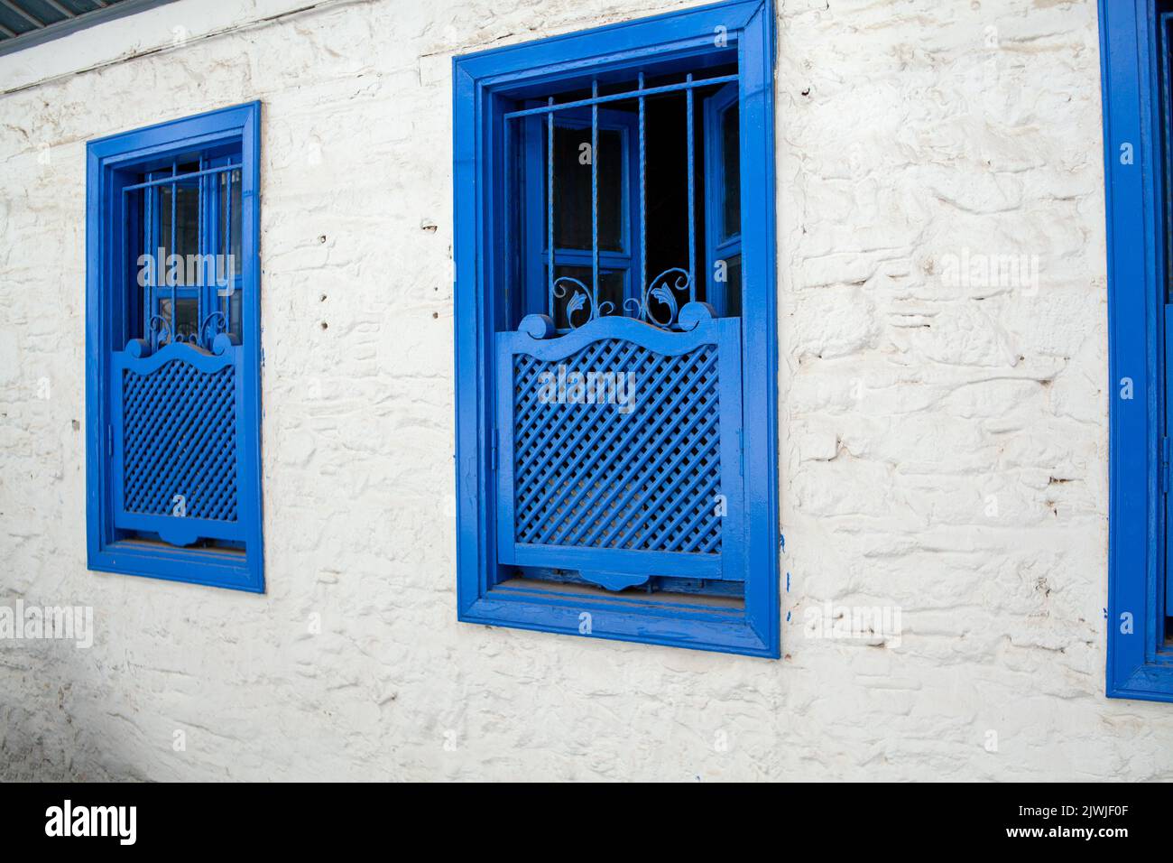 Blue window shutters on a white house. Wooden windows with closed ...