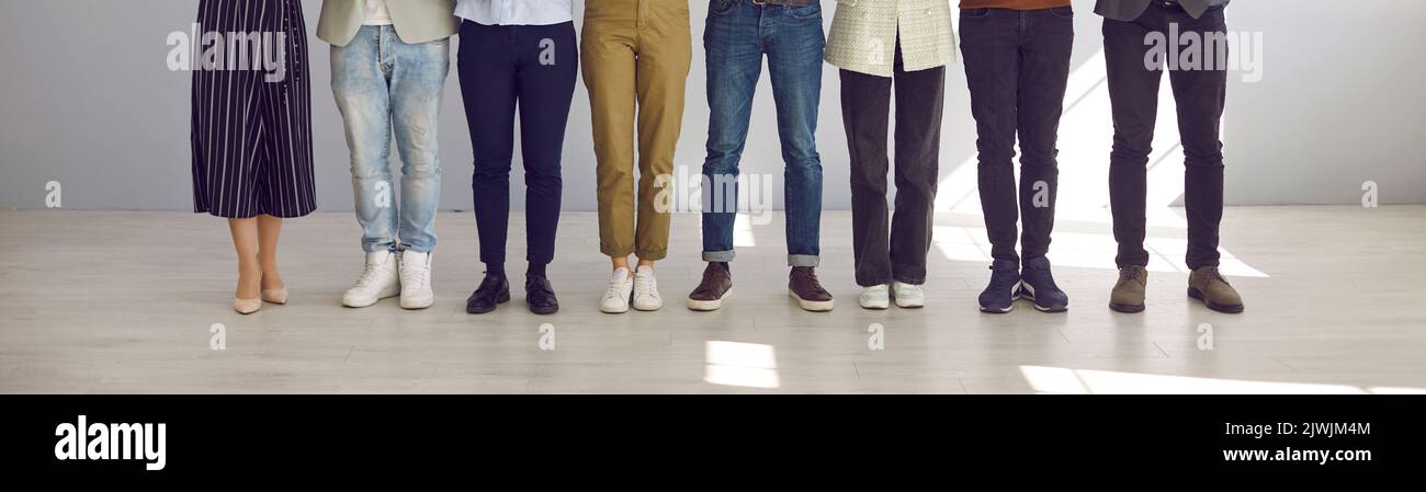 Group of different people in pants and jeans standing in office, low ...