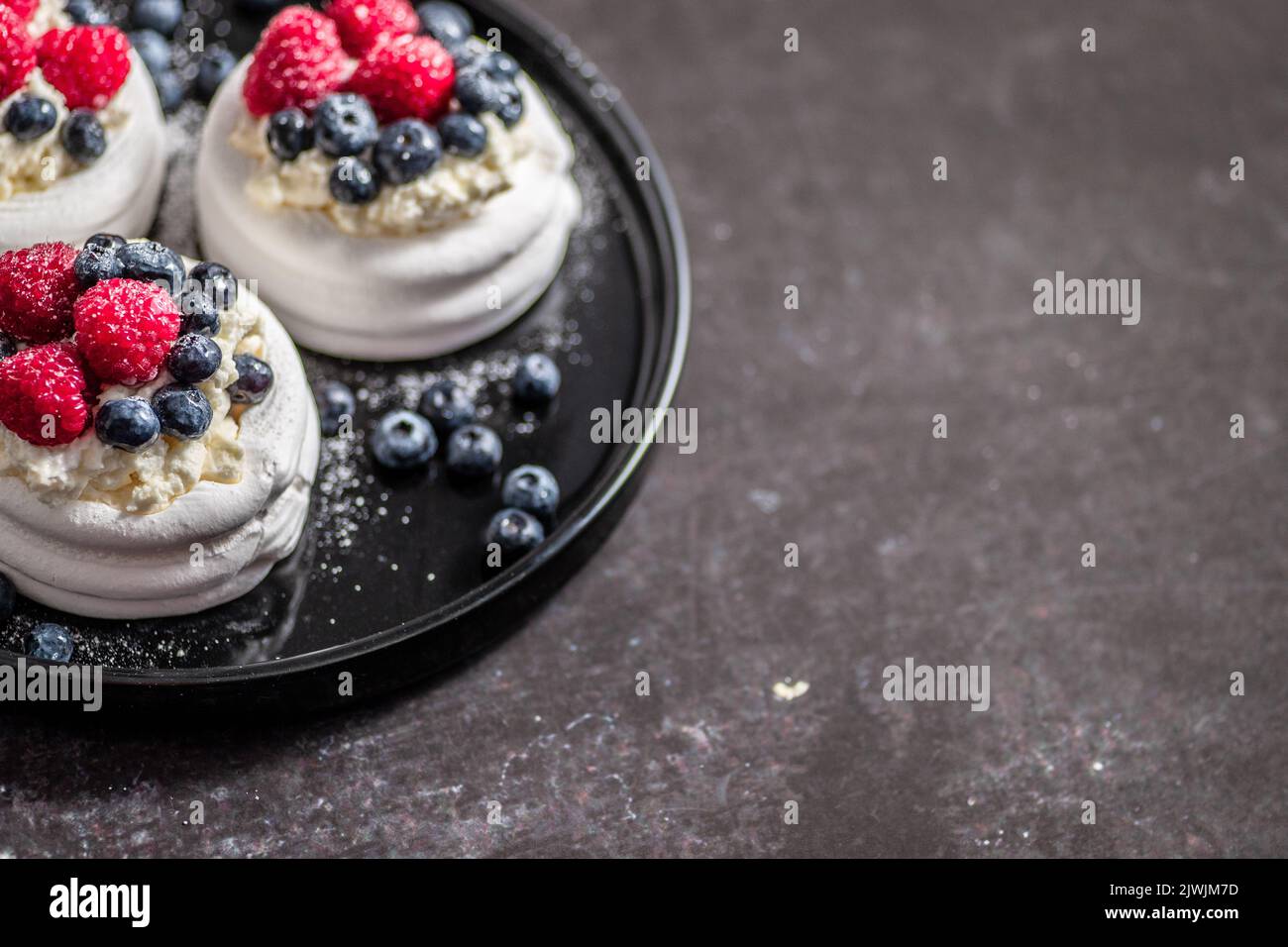 Mini Pavlova cakes topped with berries and mascarpone cheese Stock ...