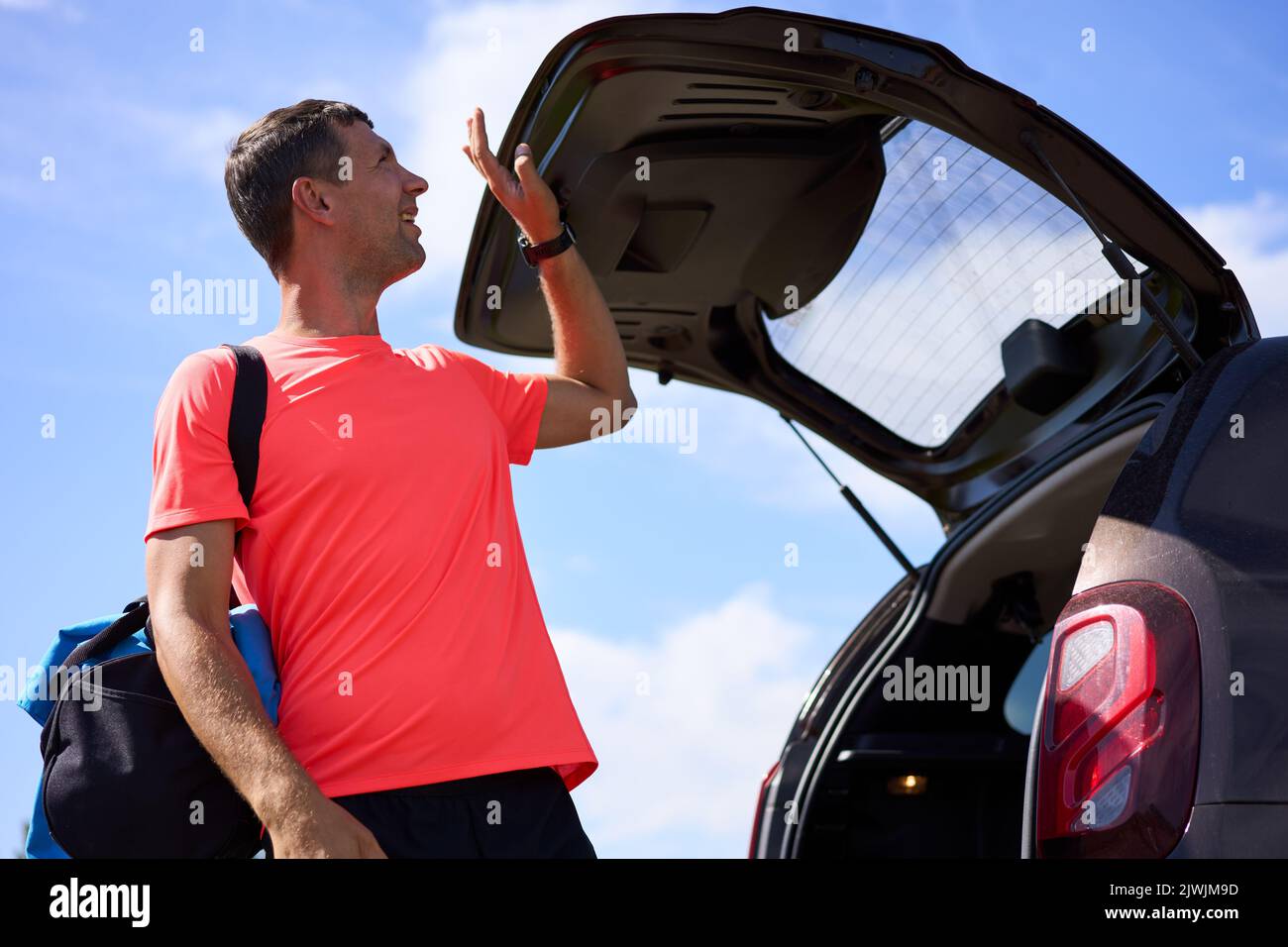 Sportsman getting bag out of trunk outdoors. Concept of sport lifestyle ...