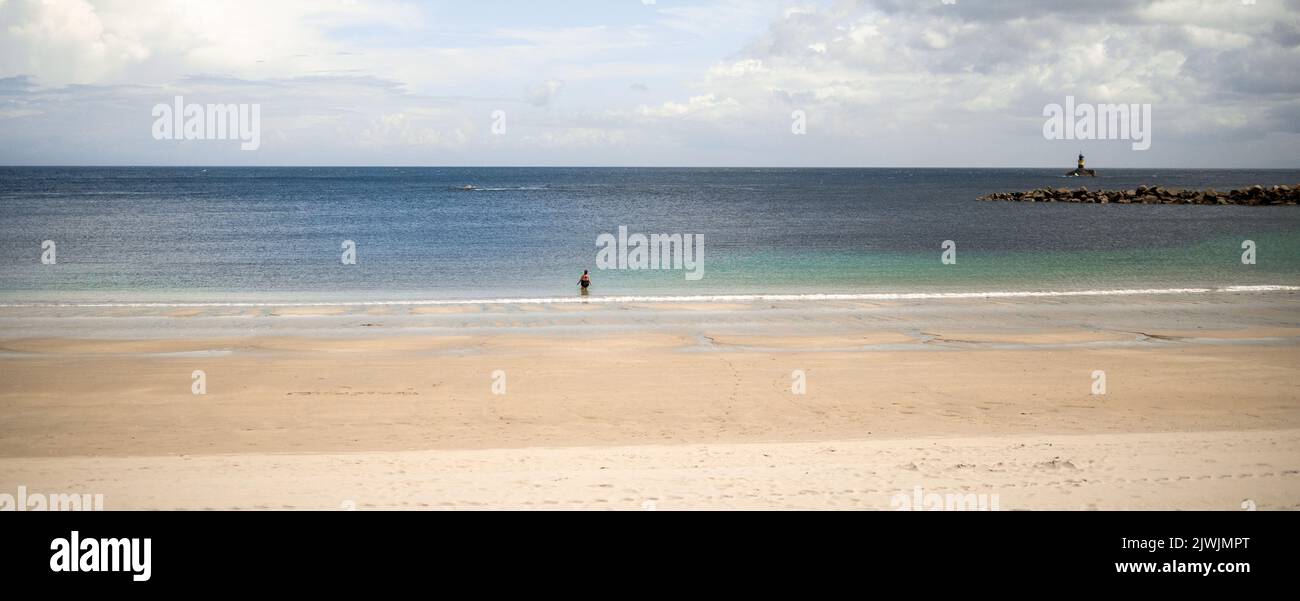 a lonely person in the middle of a beach Stock Photo - Alamy