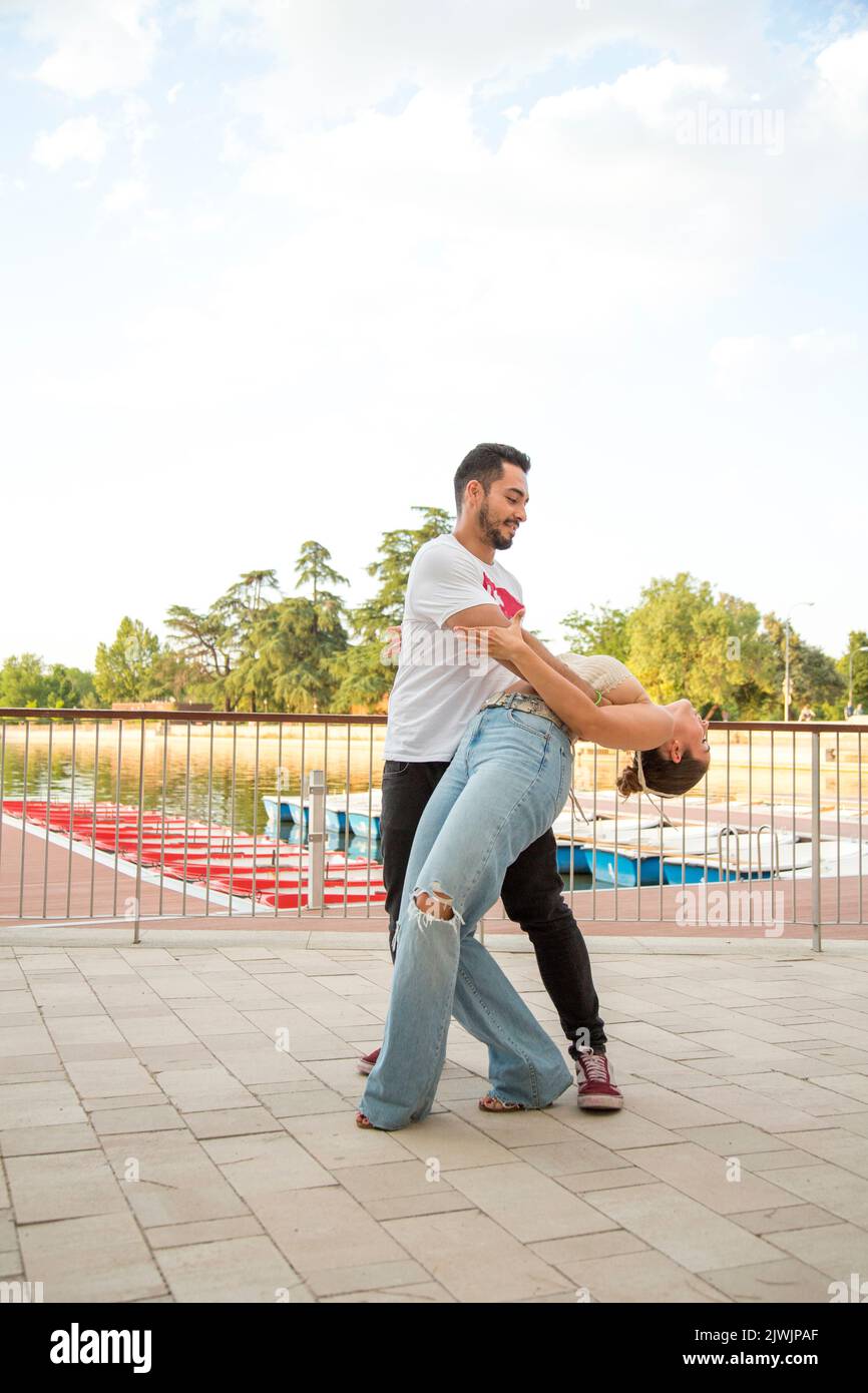 Vertical photo of a casual caucasian young couple dancing tango next to ...