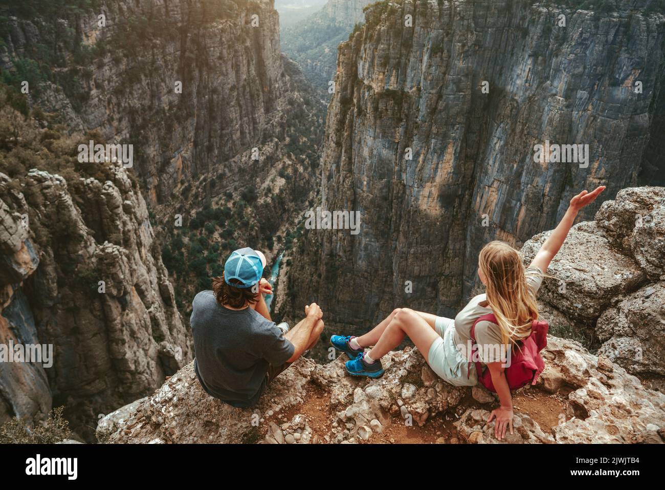Couple hiking together sitting on cliff edge travel healthy lifestyle ...