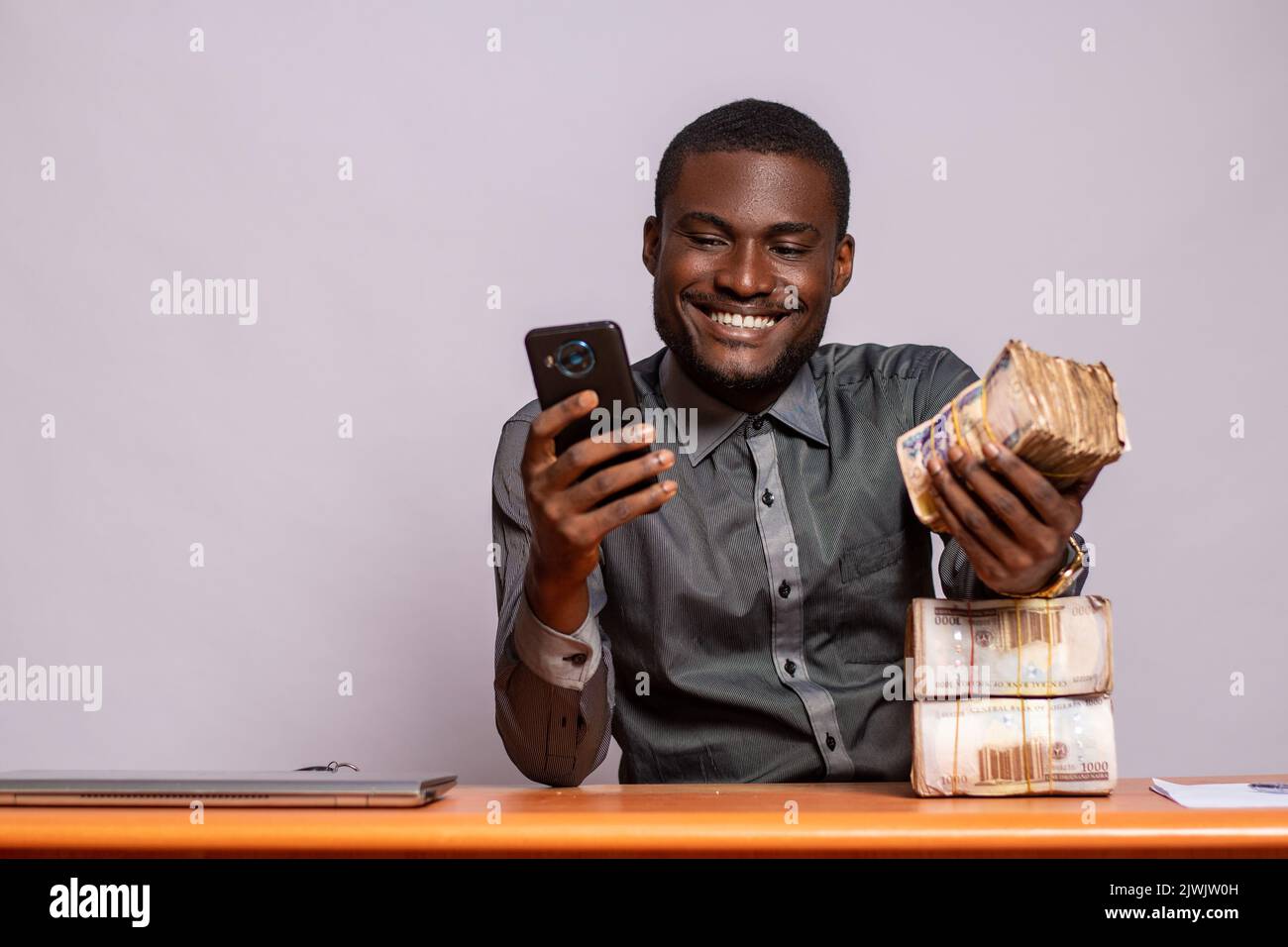 happy african businessman holding money and using his phone Stock Photo ...