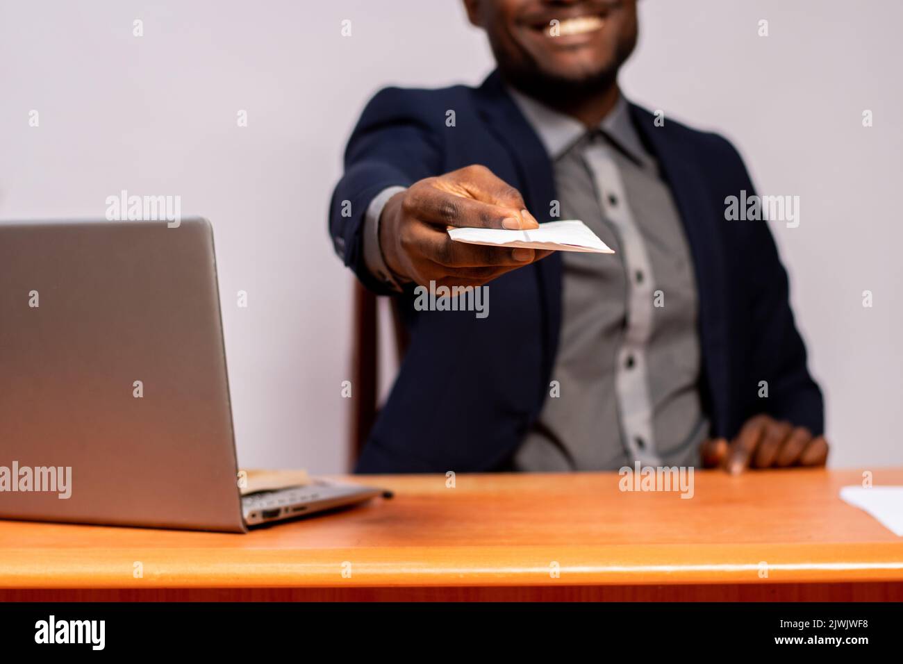 african businessman giving someone an envelope Stock Photo - Alamy