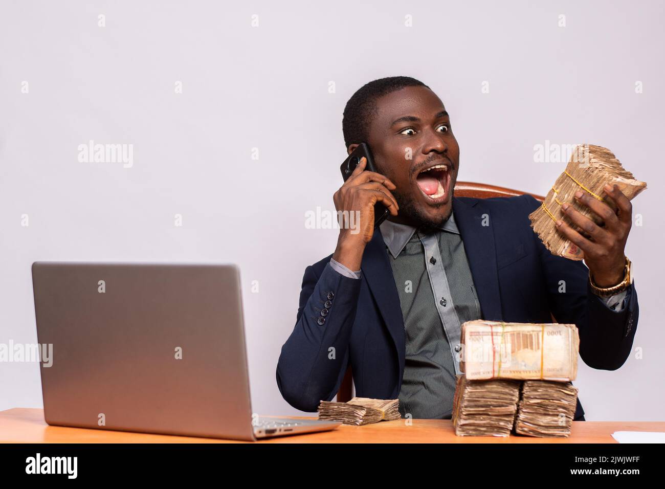 excited black businessman at work with lots of money on call Stock ...