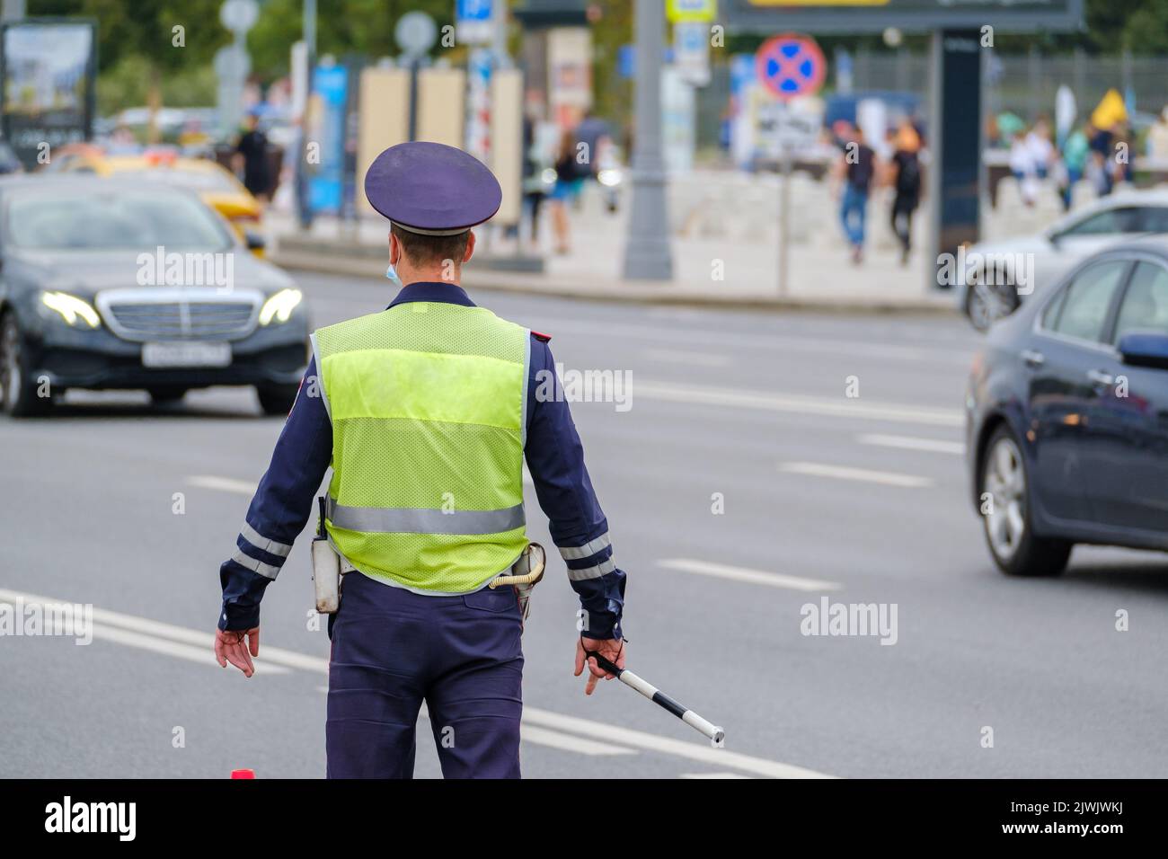 Back view of anonymous man in traffic police uniform and safety vest ...