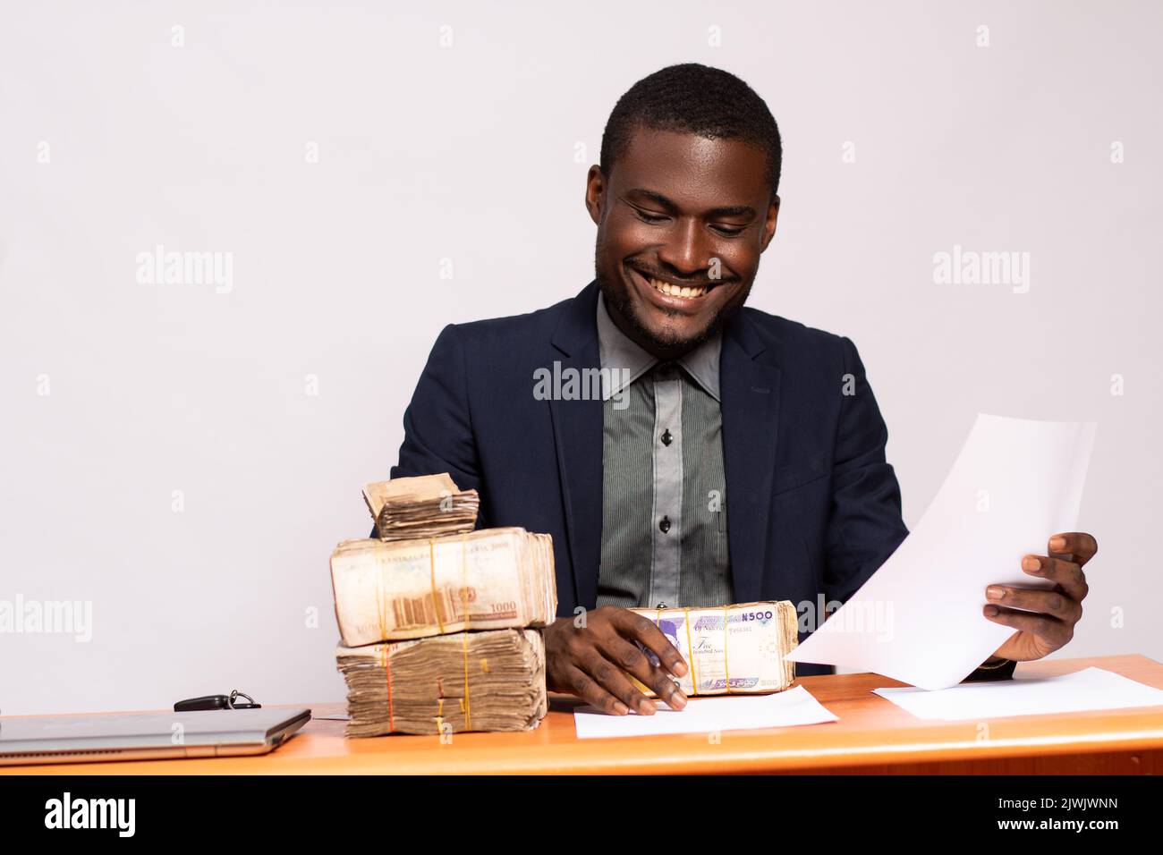 african businessman at work with lots of money Stock Photo - Alamy
