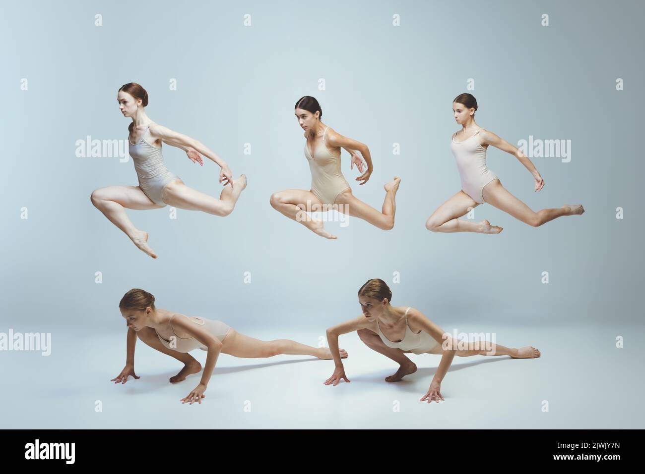 Group of young girls, ballet dancers performing, posing isolated over grey studio background ...