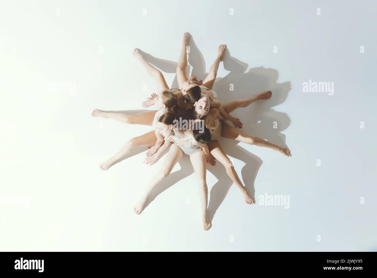 Group of young girls, ballet dancers performing, sitting on floor in a ...