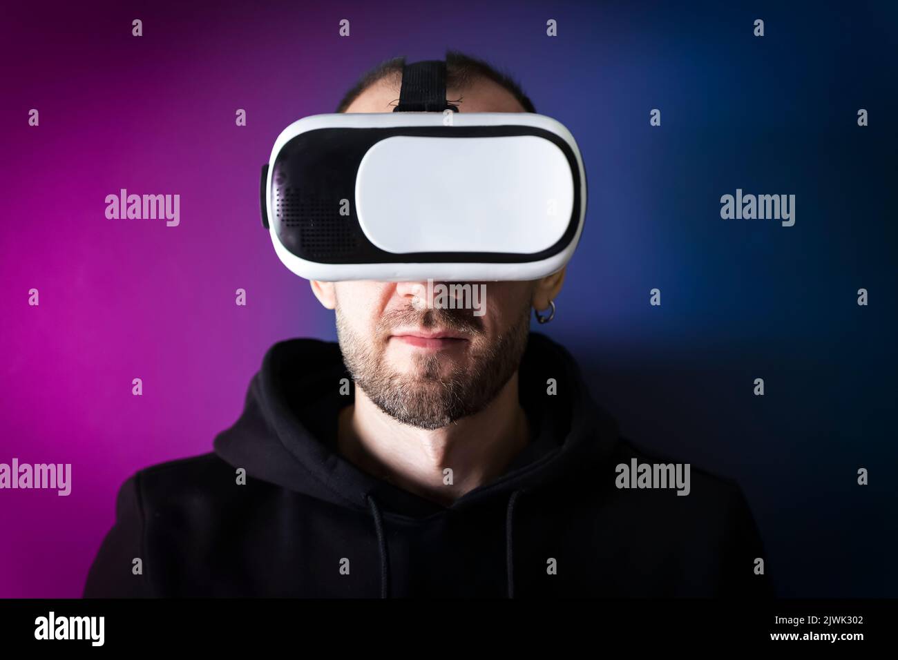 Man uses virtual reality glasses on neon cyber background. Metaverse ...