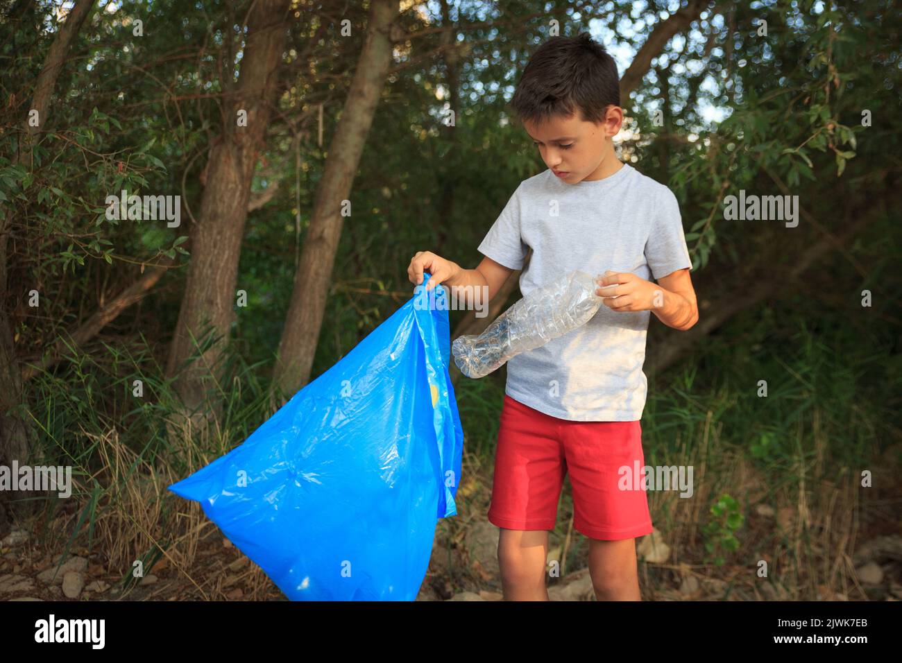child collects garbage in nature. Educational activities to recycle ...