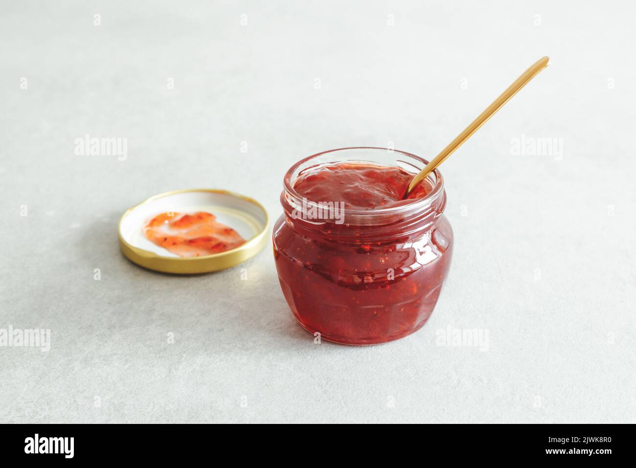 Ready to eat dessert. Homemade jar of strawberry jam, golden spoon and ...