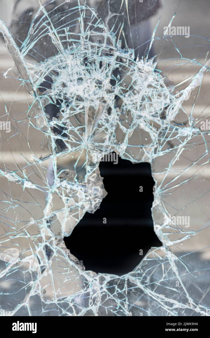 Hole in the broken glass of a shop window of a closed shop Stock Photo ...