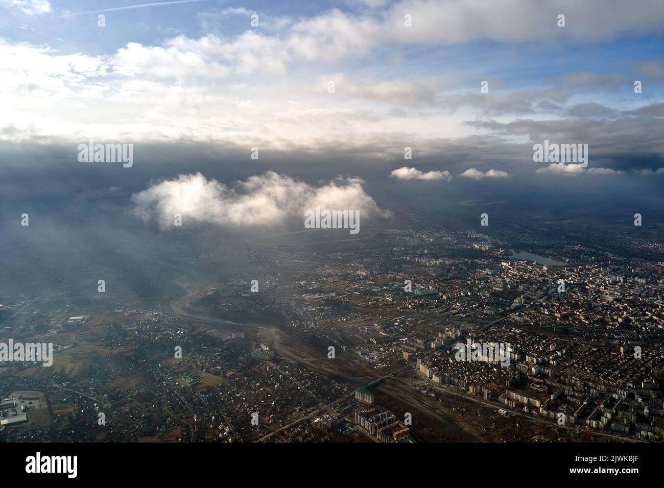 Aerial view from high altitude of distant city covered with puffy ...