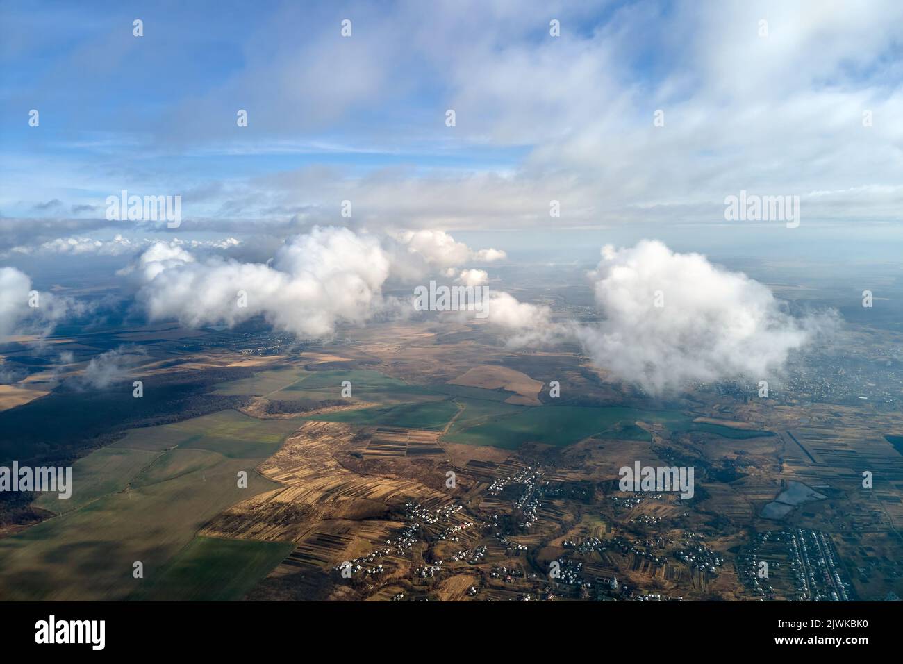 Aerial view from high altitude of distant city covered with puffy ...