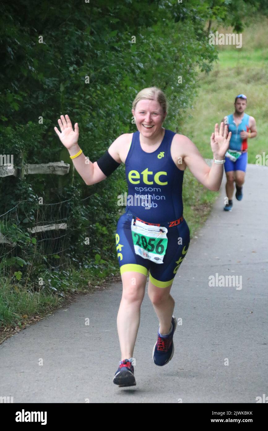 smiling and waving happy triathlete running Stock Photo - Alamy