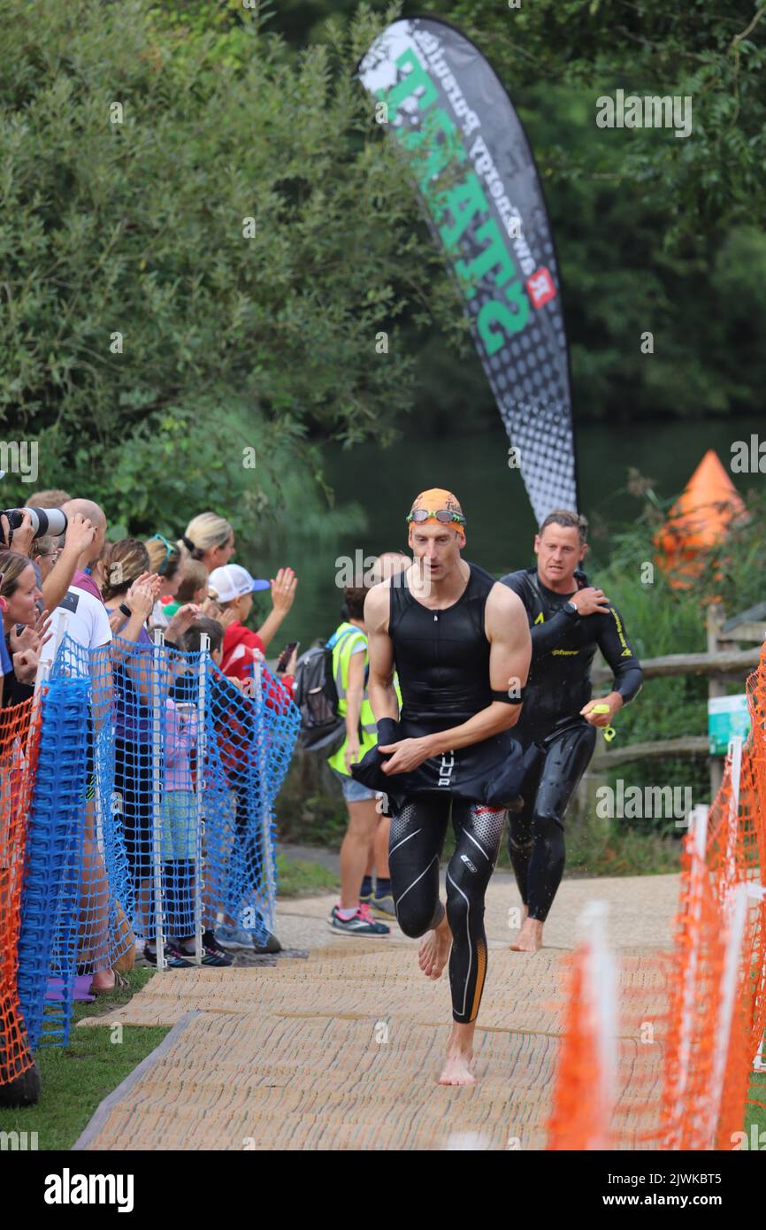 triathlete removing wetsuit at a triathlon Stock Photo - Alamy