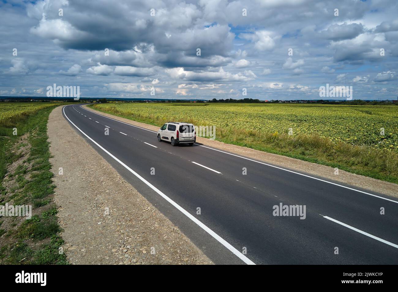 Aerial view of intercity road between green agricultural fields with ...