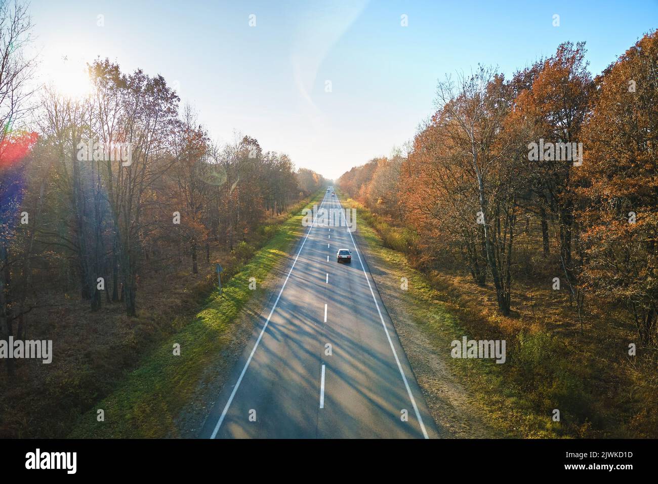 Aerial view of intercity road with blurred fast driving car at sunset ...