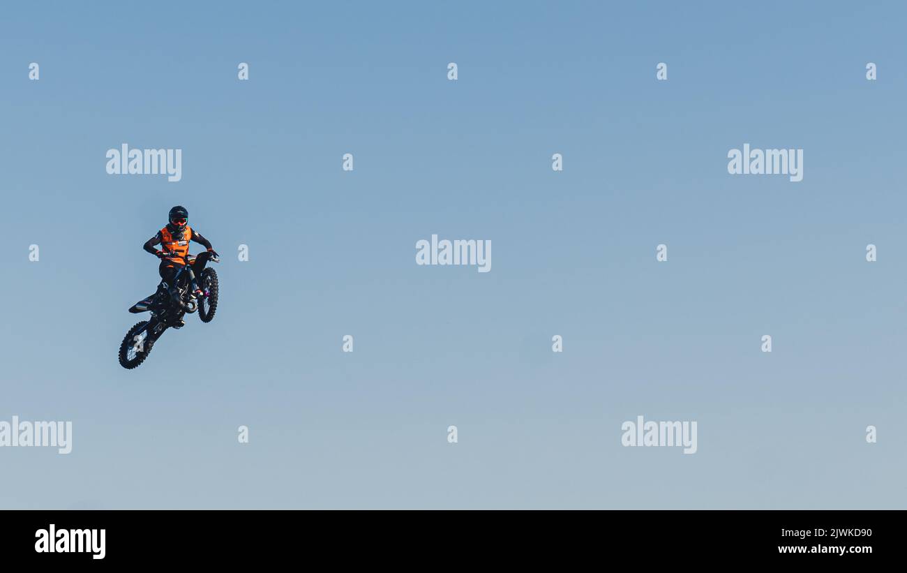 Extreme sports concept. Bike rider jumping high in the air. Wide ...