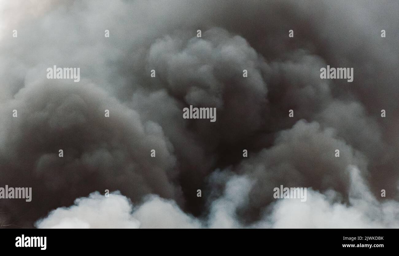 A cloud of black smoke from a fire in a building materials warehouse ...