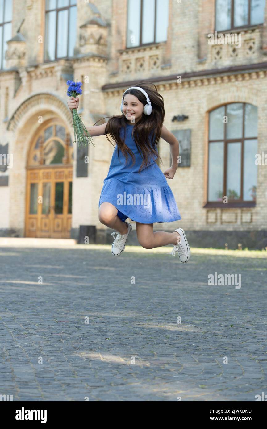 positive teen girl in headphones. girl jump outdoor. carefree girl ...