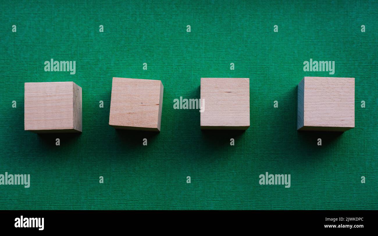 Four wooden cubes on a green background, mocap Stock Photo - Alamy