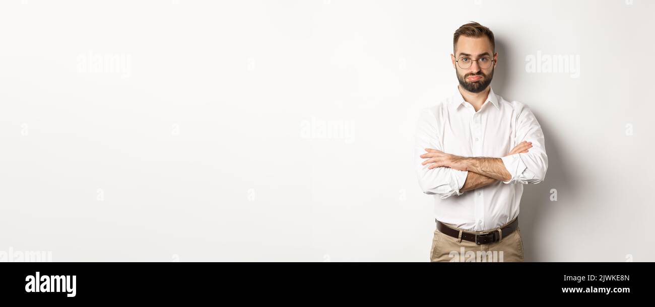 Disappointed businessman pouting, standing displeased against white ...