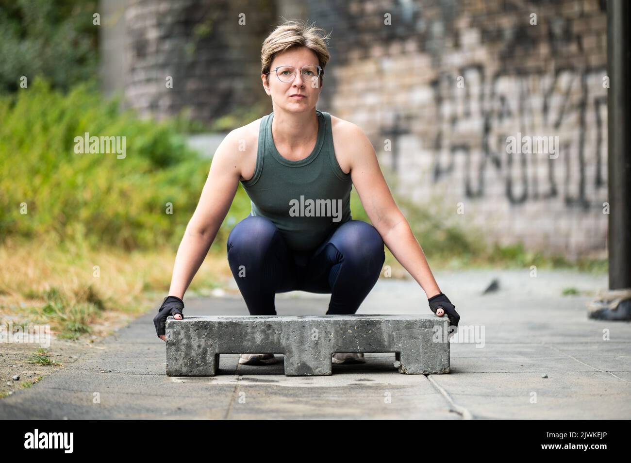 Portrait of a sporty 36 year old white woman lifting a heavy ...