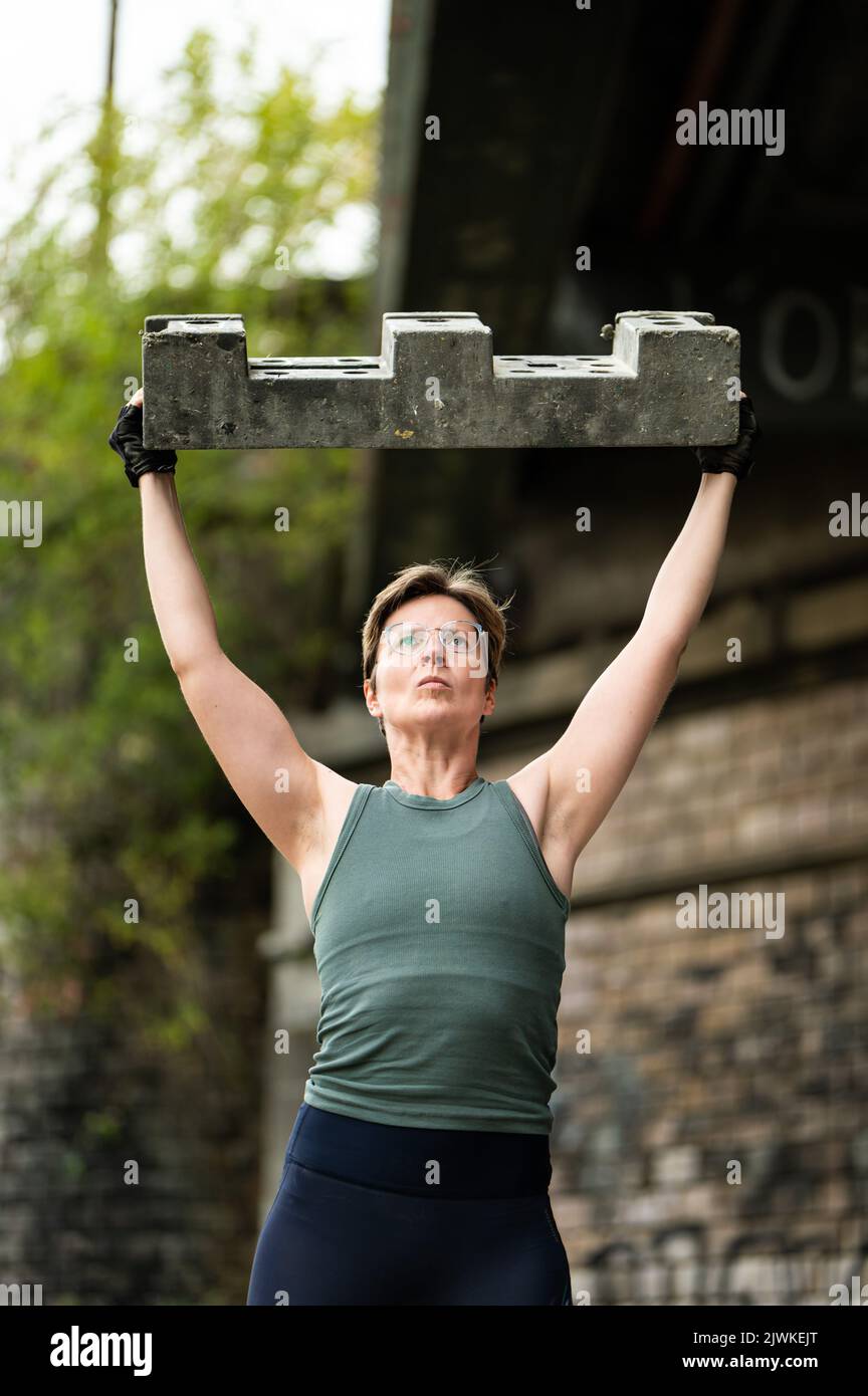 Portrait of a sporty 36 year old white woman lifting a heavy ...