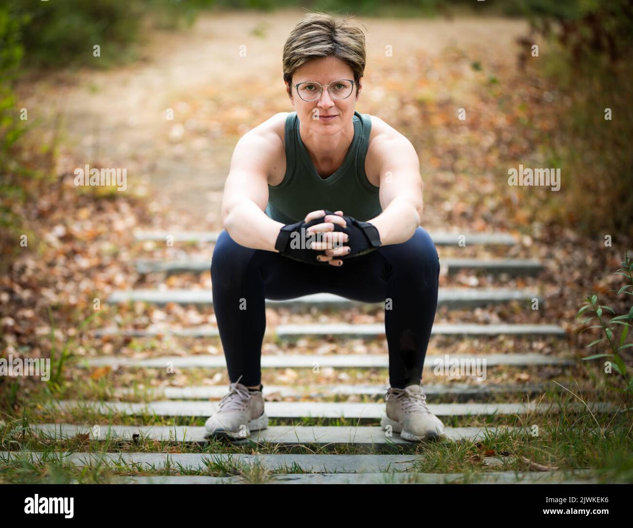Active 36 year old white woman doing a squat outdoors, Brussels ...