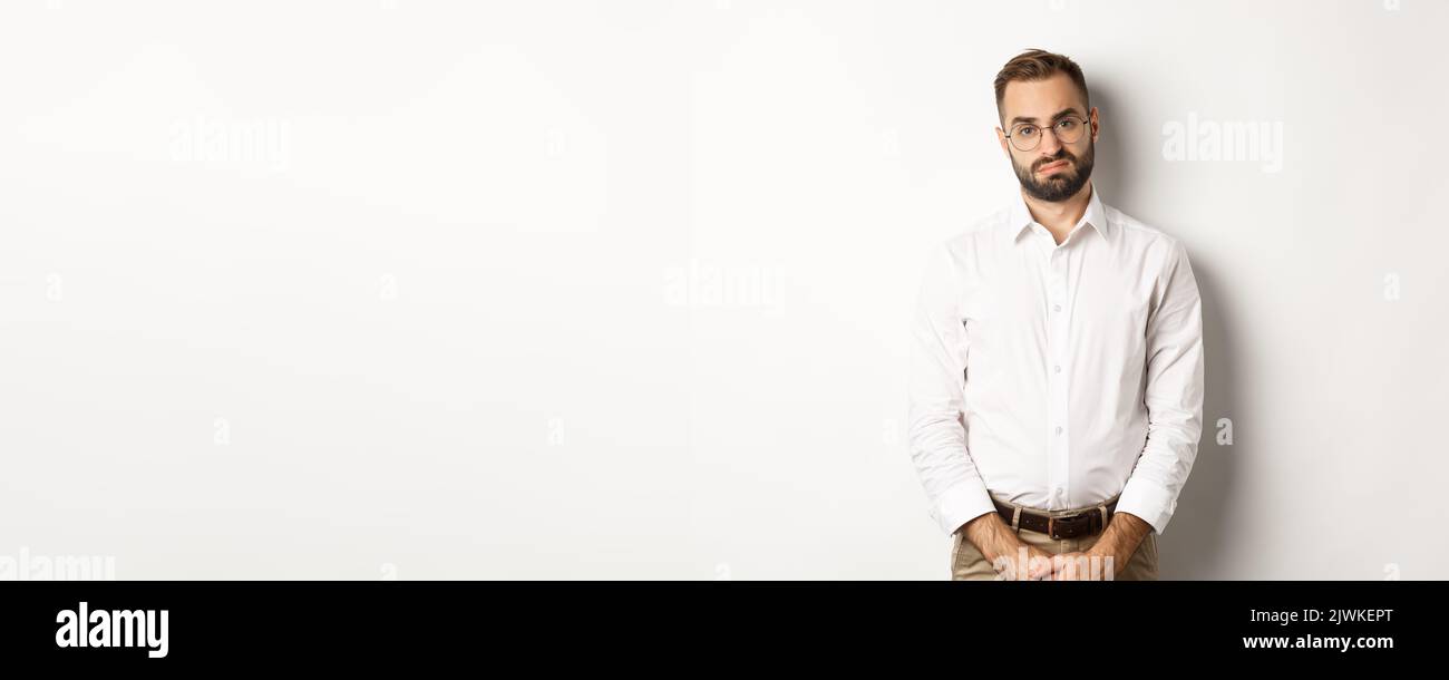 Sad and gloomy office manage frowning, standing tired against white ...