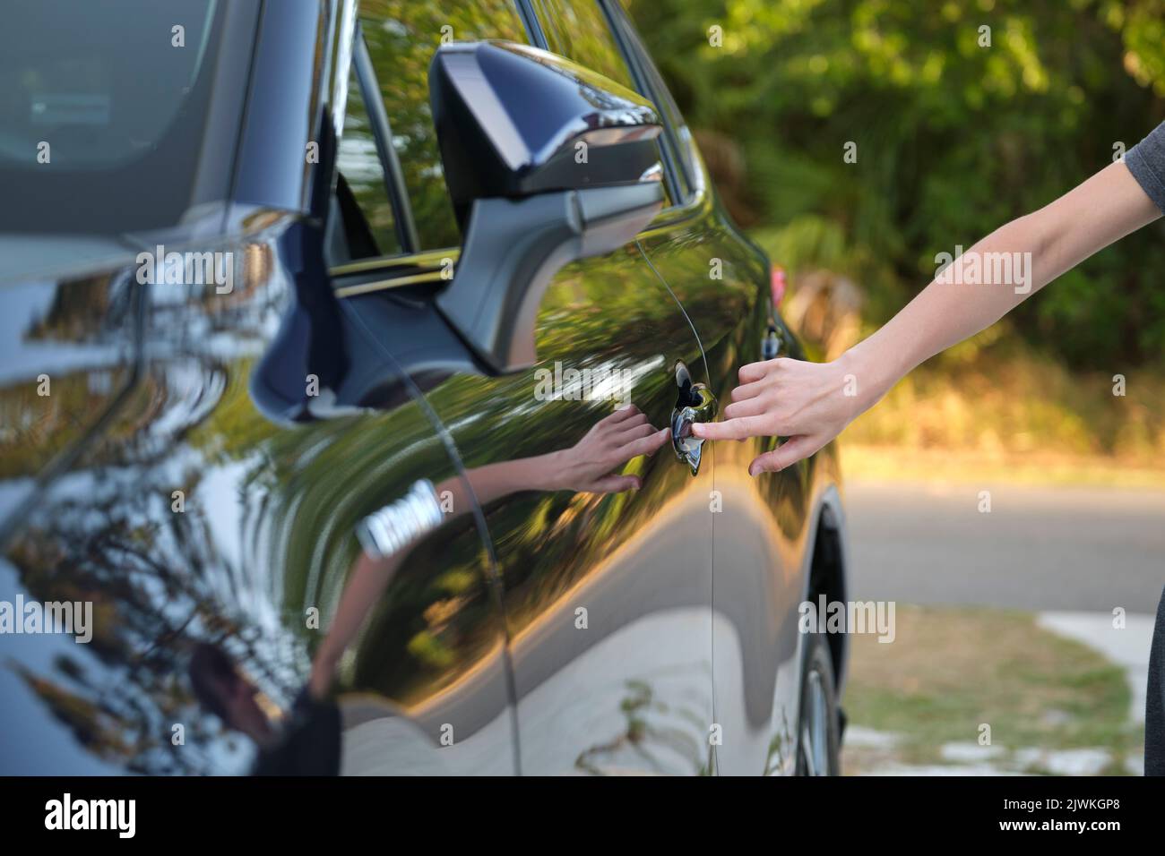Closeup of driver hand opening car front door with touch ID finger ...