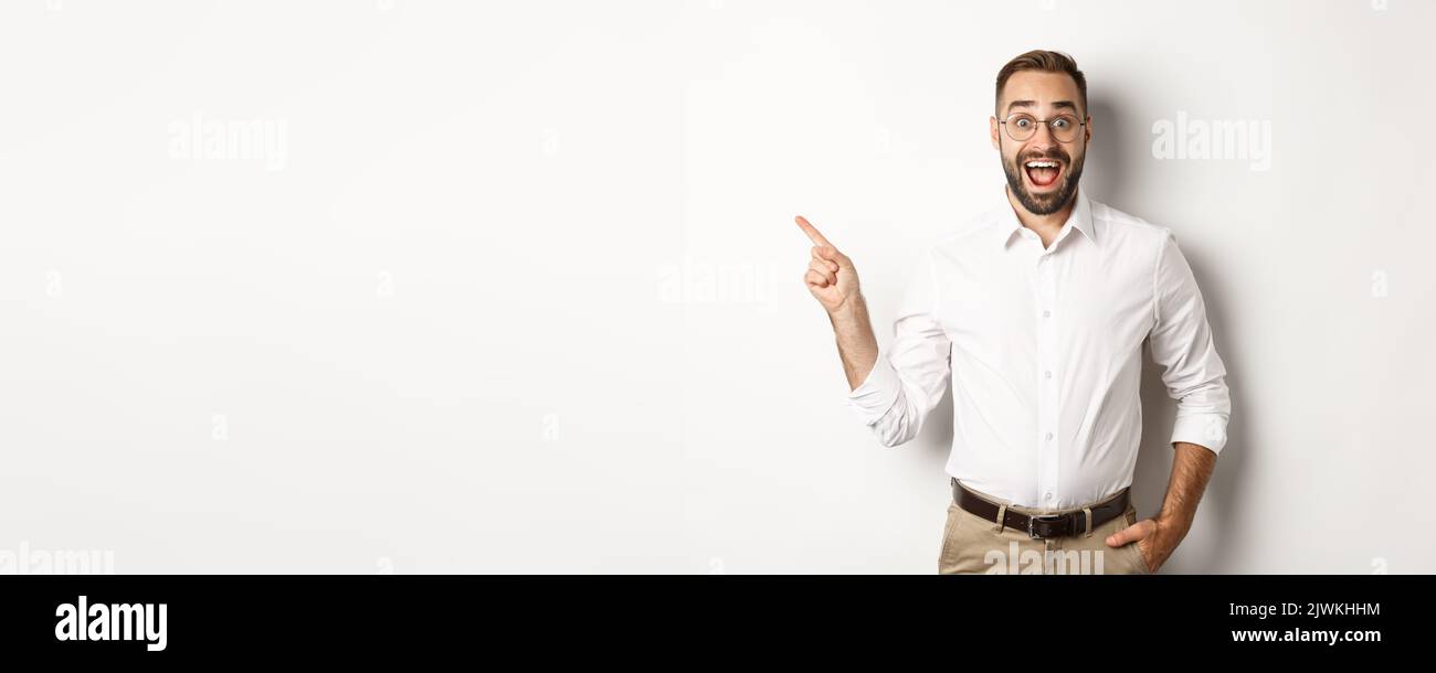 Surprised and excited man making announcement. Businessman pointing ...