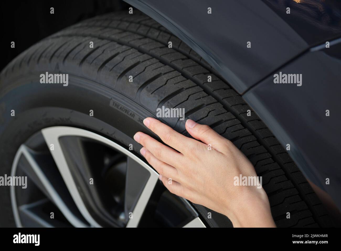 Female driver hands inspecting wheel tire of her new car. Vehicle ...