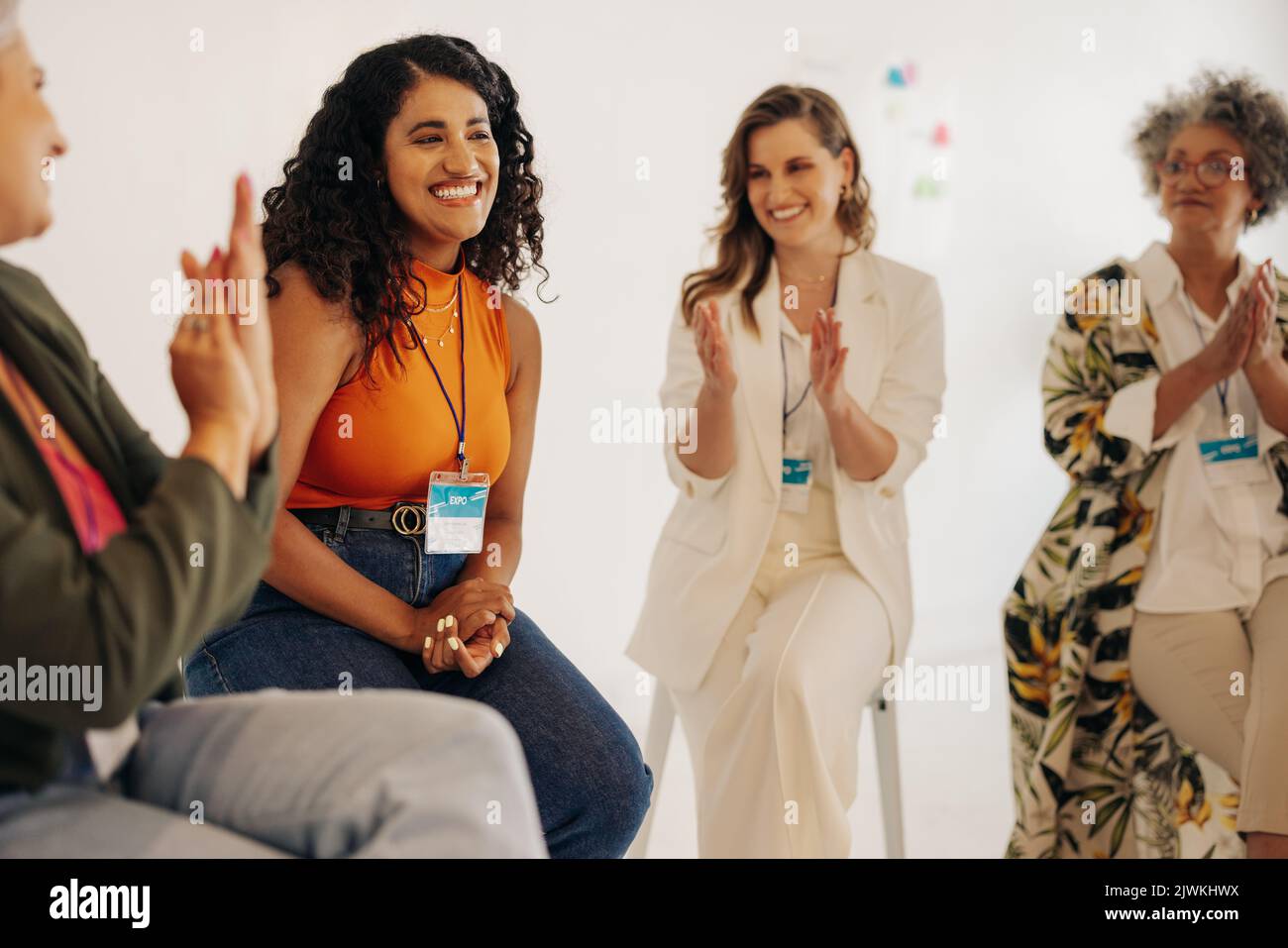 Happy businesswomen applauding their team mate during a conference ...